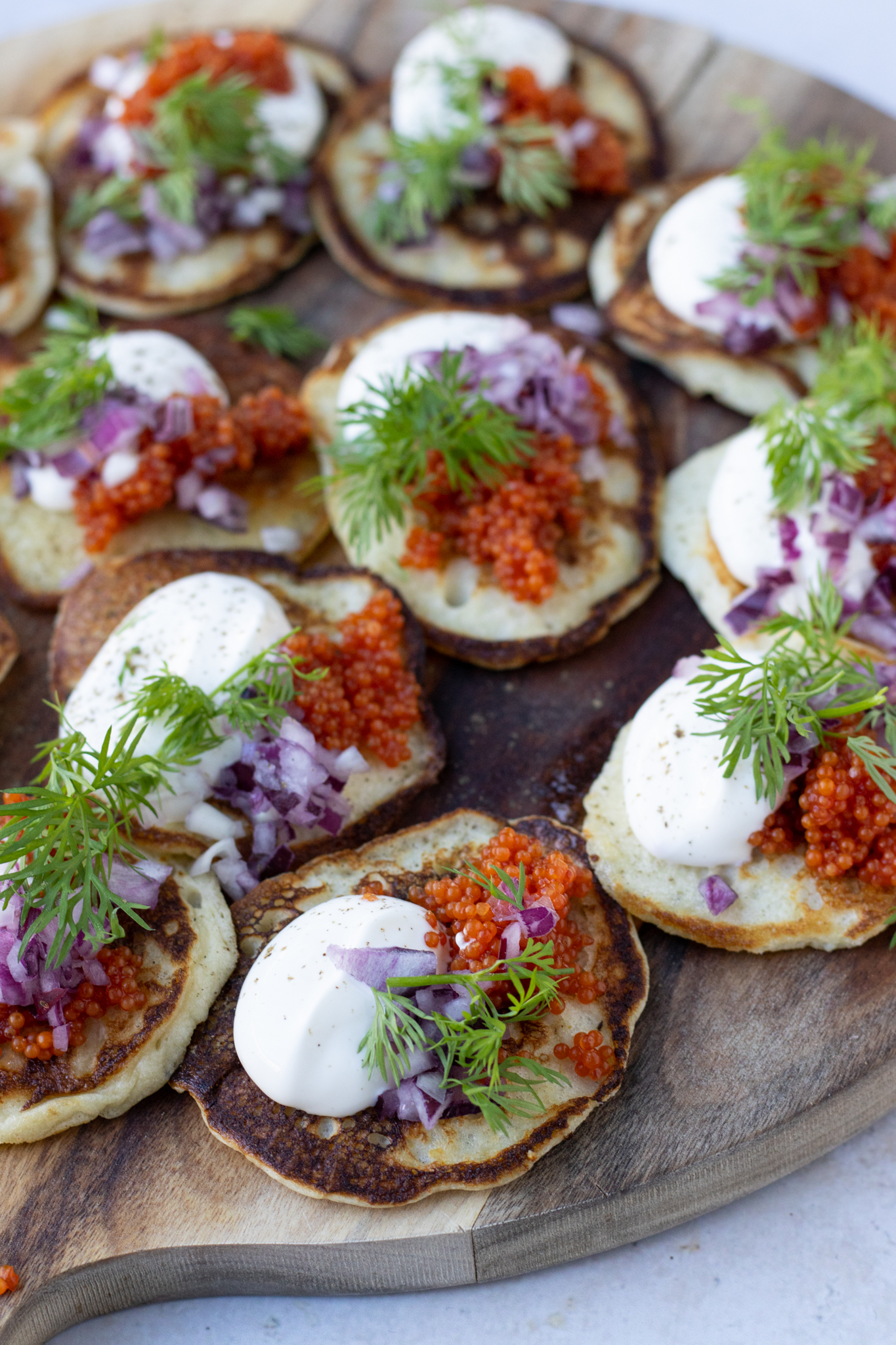 Blinis med stenbiderrogn, creme fraiche, rødløg og frisk dild